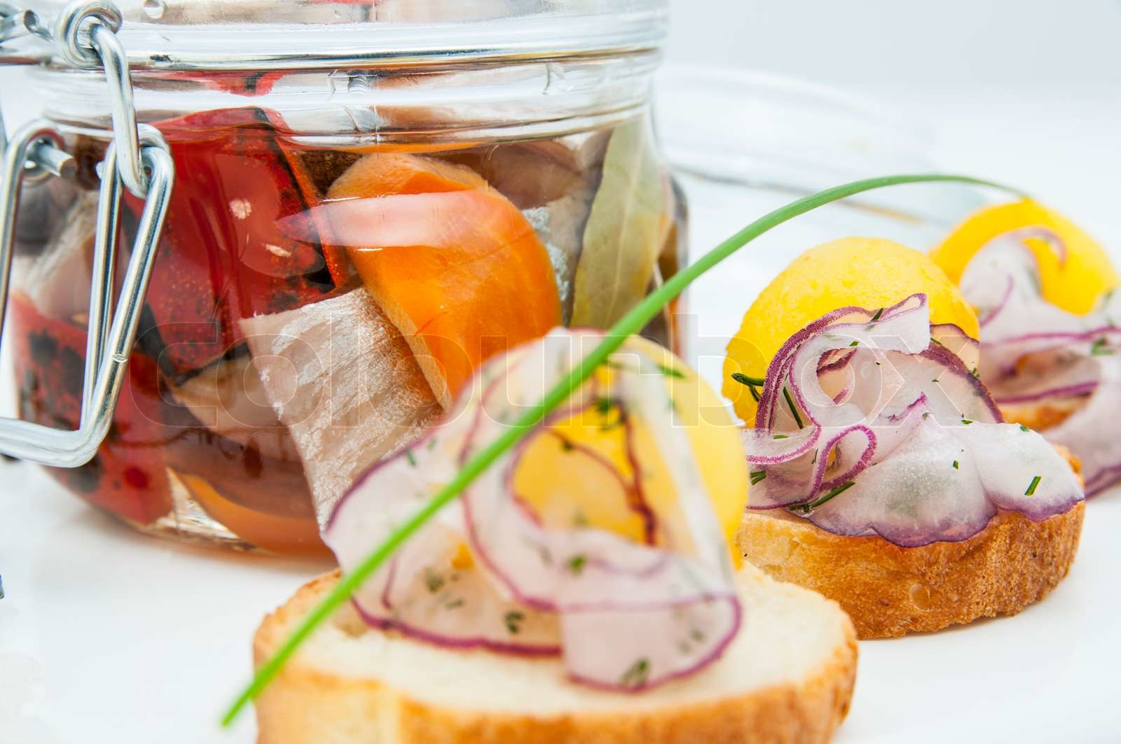 pickled herring in a glass jar with potato canapes | Stock image ...