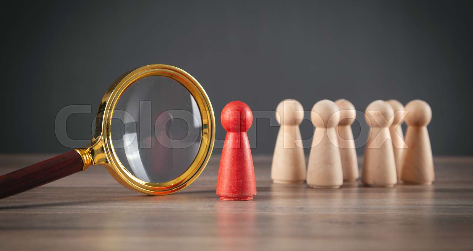 Magnifying glass and wooden human figures. | Stock image | Colourbox