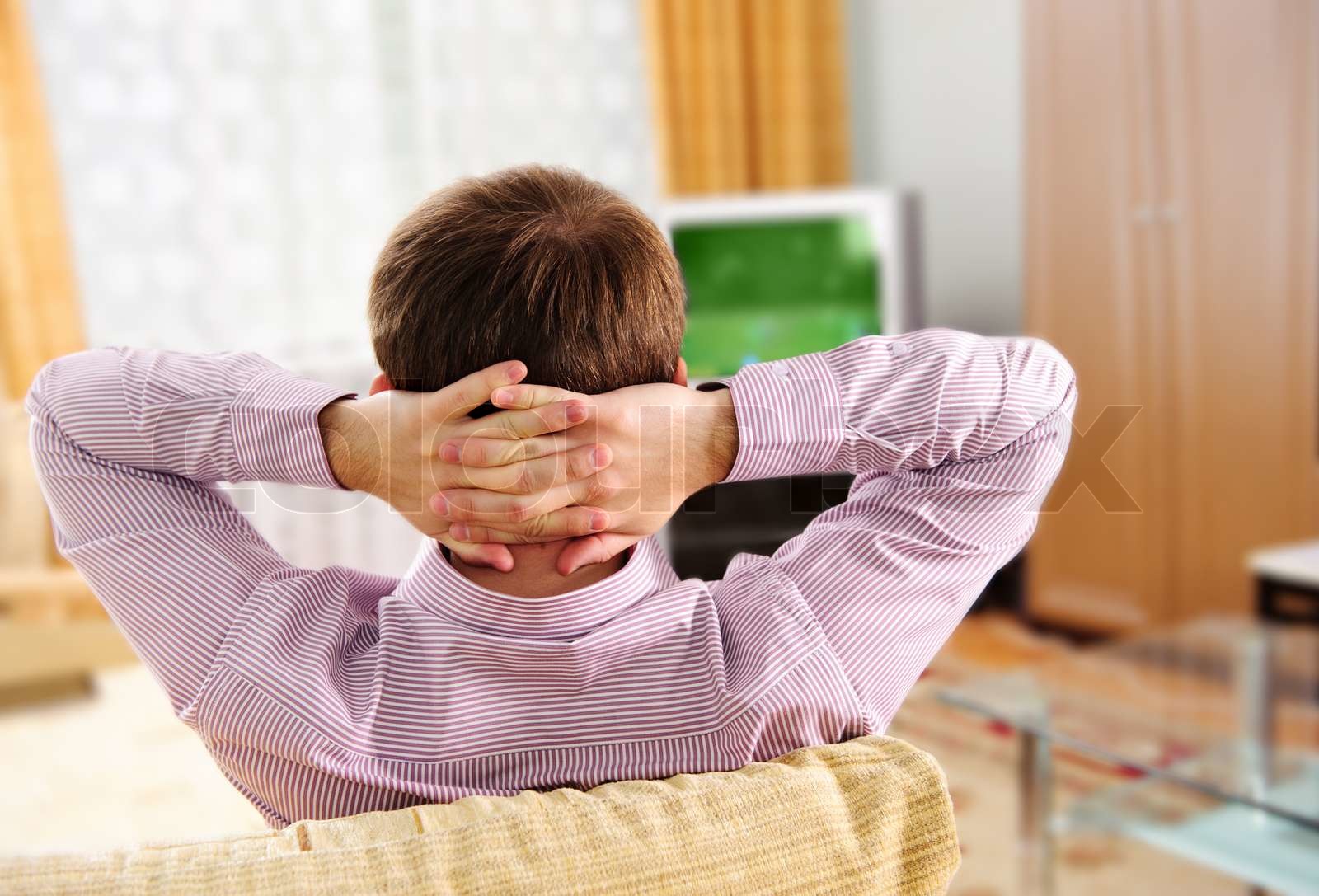 Young man watching tv at home | Stock image | Colourbox
