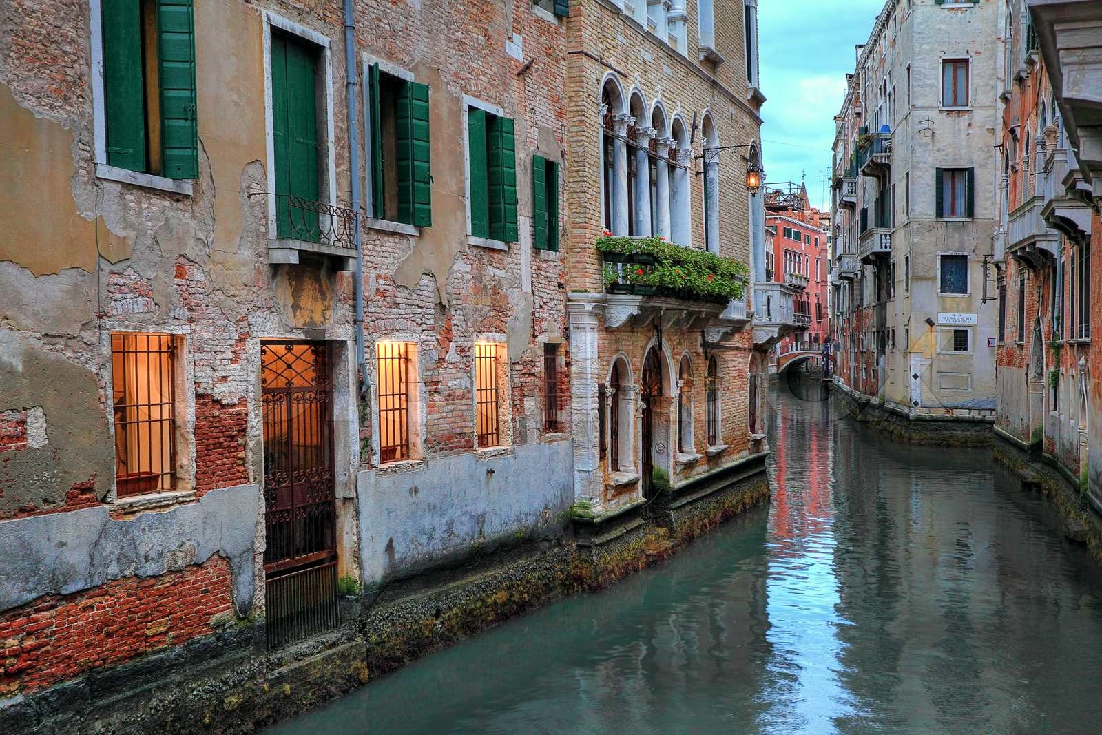 Small canal among old brick traditional venetian houses with ...
