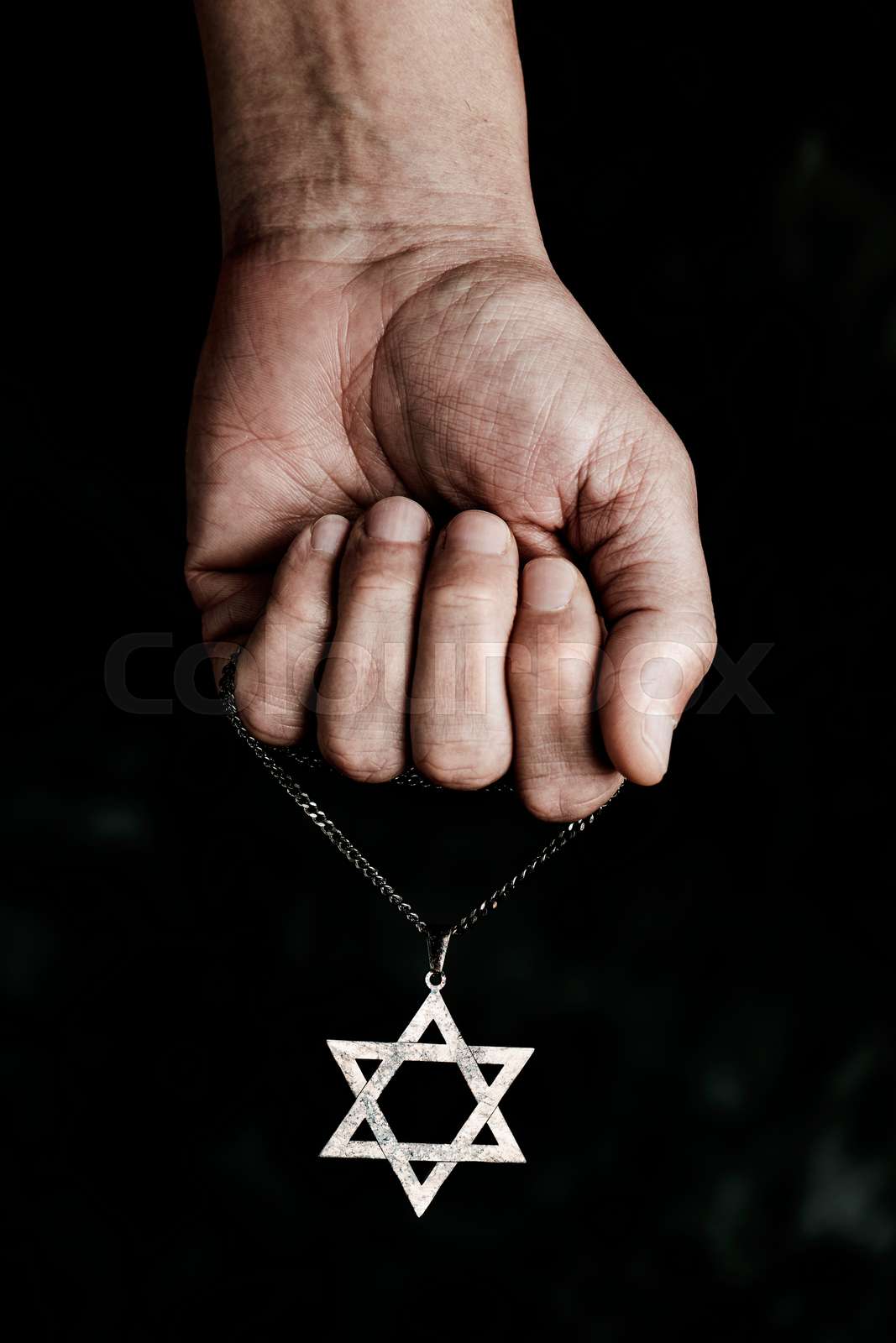 pendant in the shape of star of david in his hand | Stock image | Colourbox