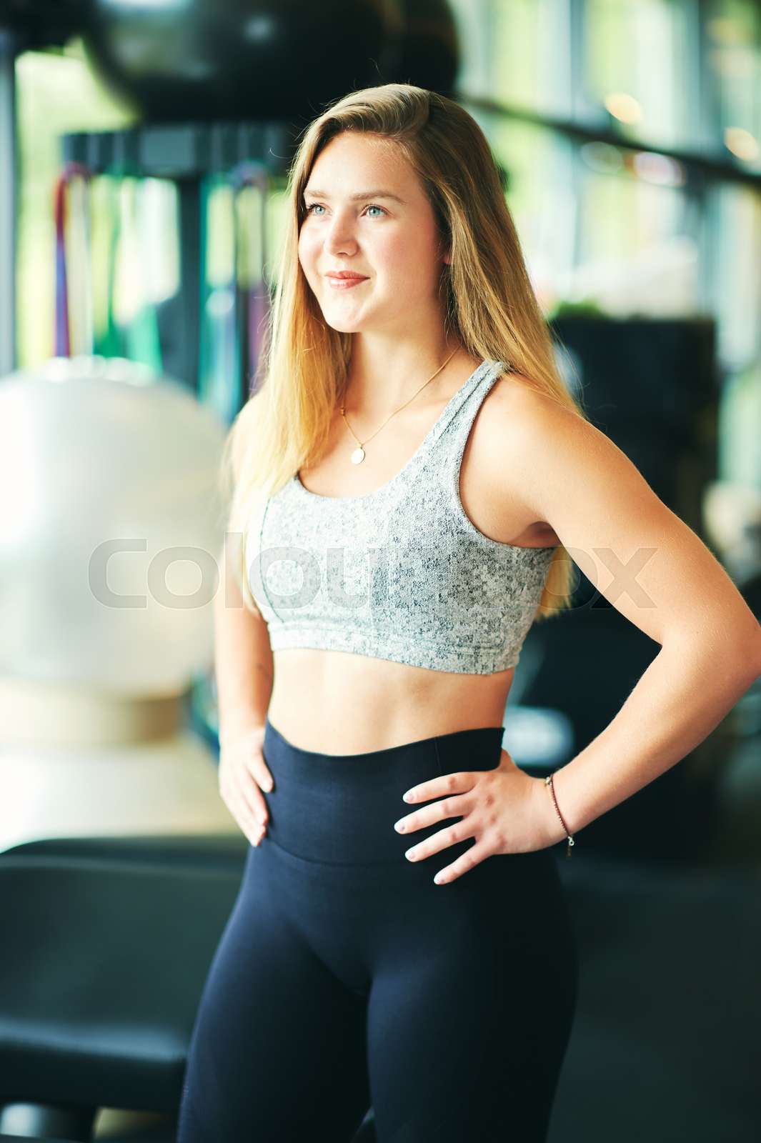 Indoor portrait of happy young fit woman posing in gym, healthy ...