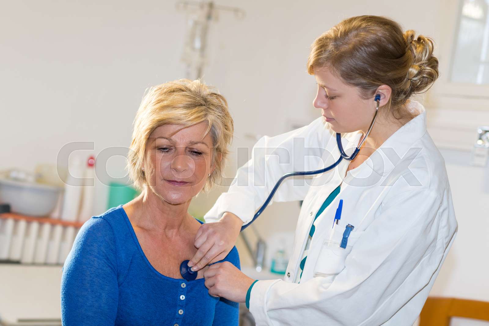 nurse is counting heart rate of a female patient | Stock image | Colourbox