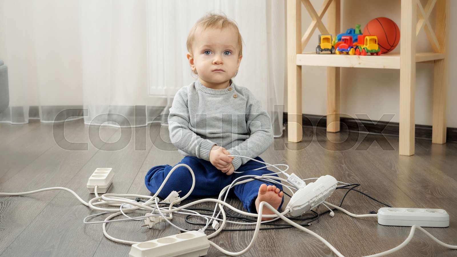 Little baby boy playing with electric plugs and wires at home | Stock ...