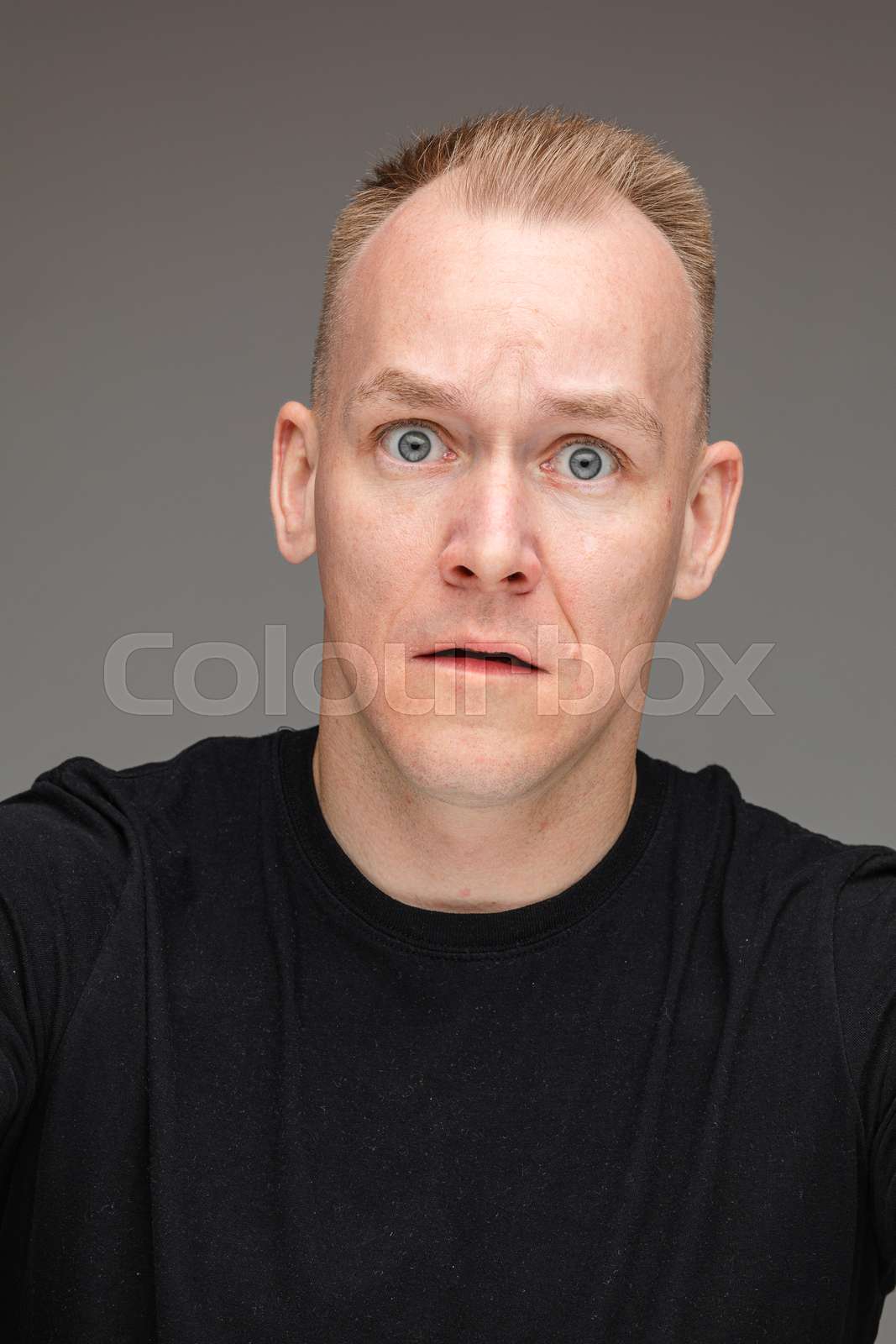 Terrified blond man with wide-open eyes. | Stock image | Colourbox