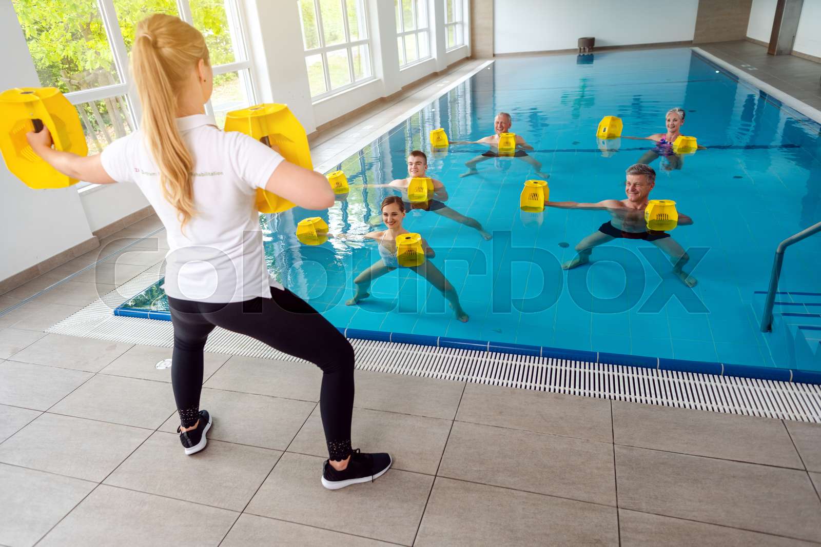 Teacher or coach in water gymnastics class | Stock image | Colourbox