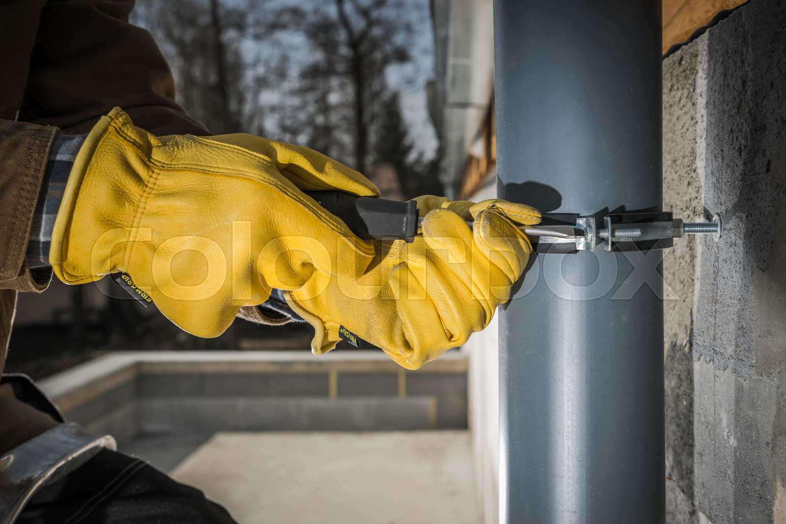 Construction Worker Attaching Home Gutters to the Building Wall | Stock ...
