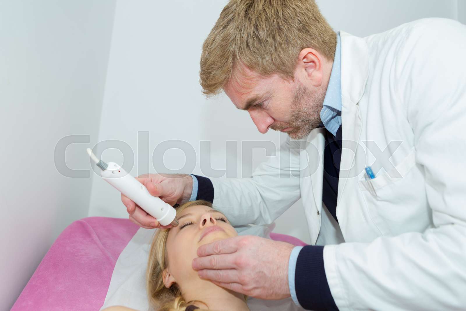 beautician colors the eyebrows of a woman in cosmetic studio | Stock ...