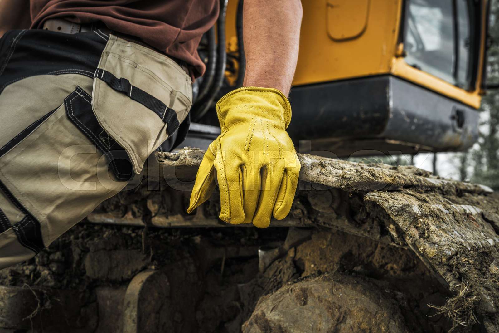 Bulldozer Operator Resting on a Caterpillar Track | Stock image | Colourbox