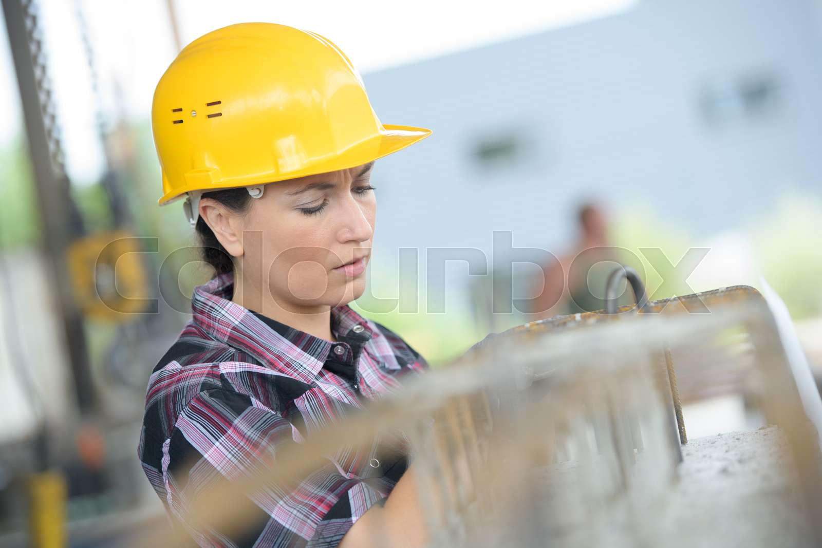 female worker on building site looking at rebars | Stock image | Colourbox