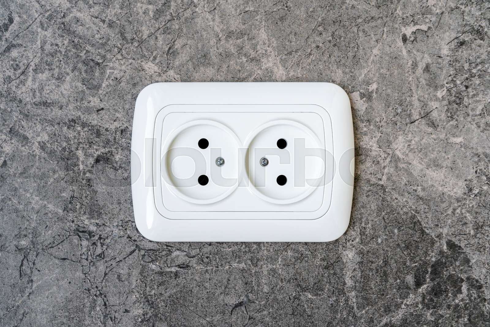 European electric outlet on tiled wall | Stock image | Colourbox