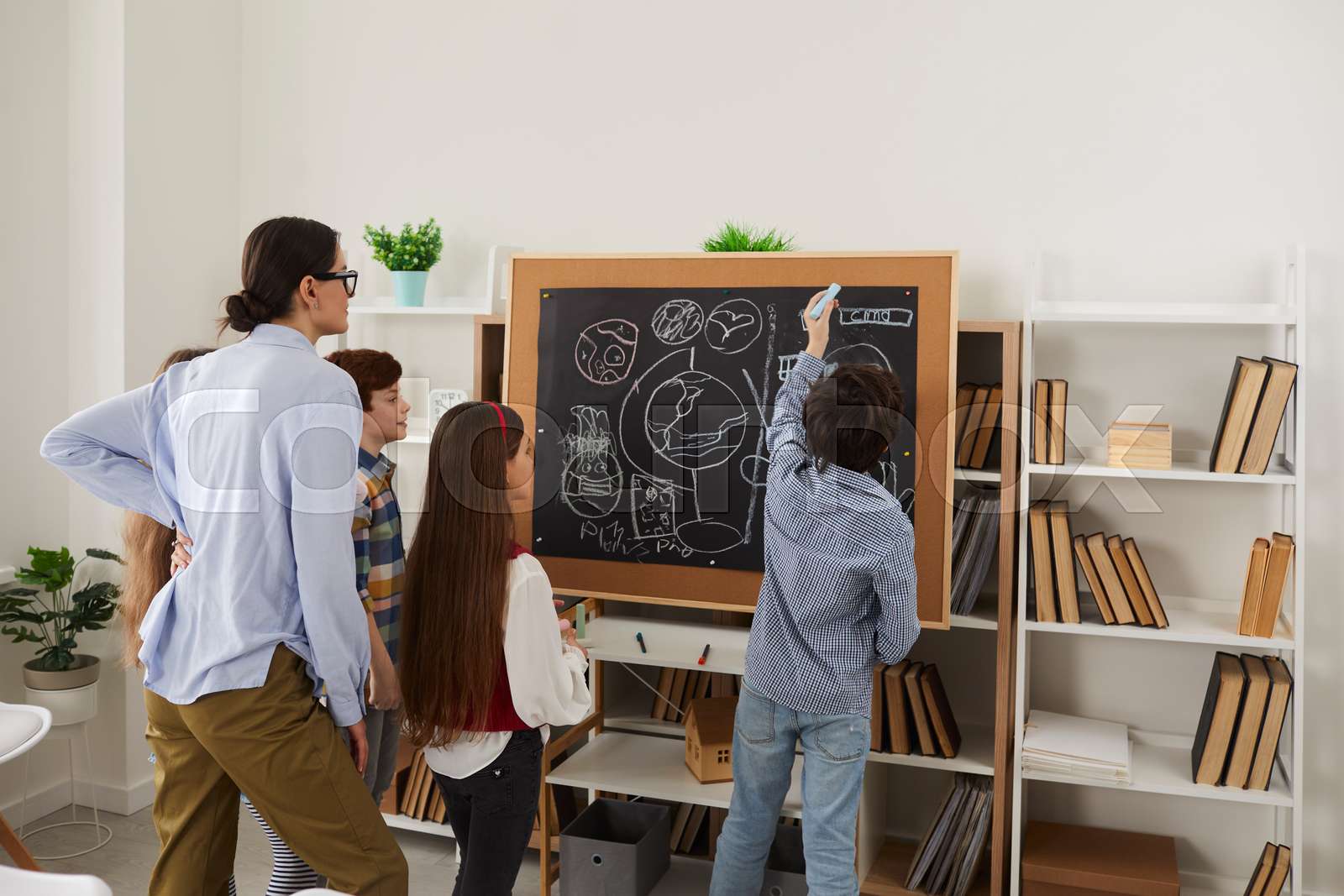 Pupils under the supervision of a teacher with chalk draw different ...