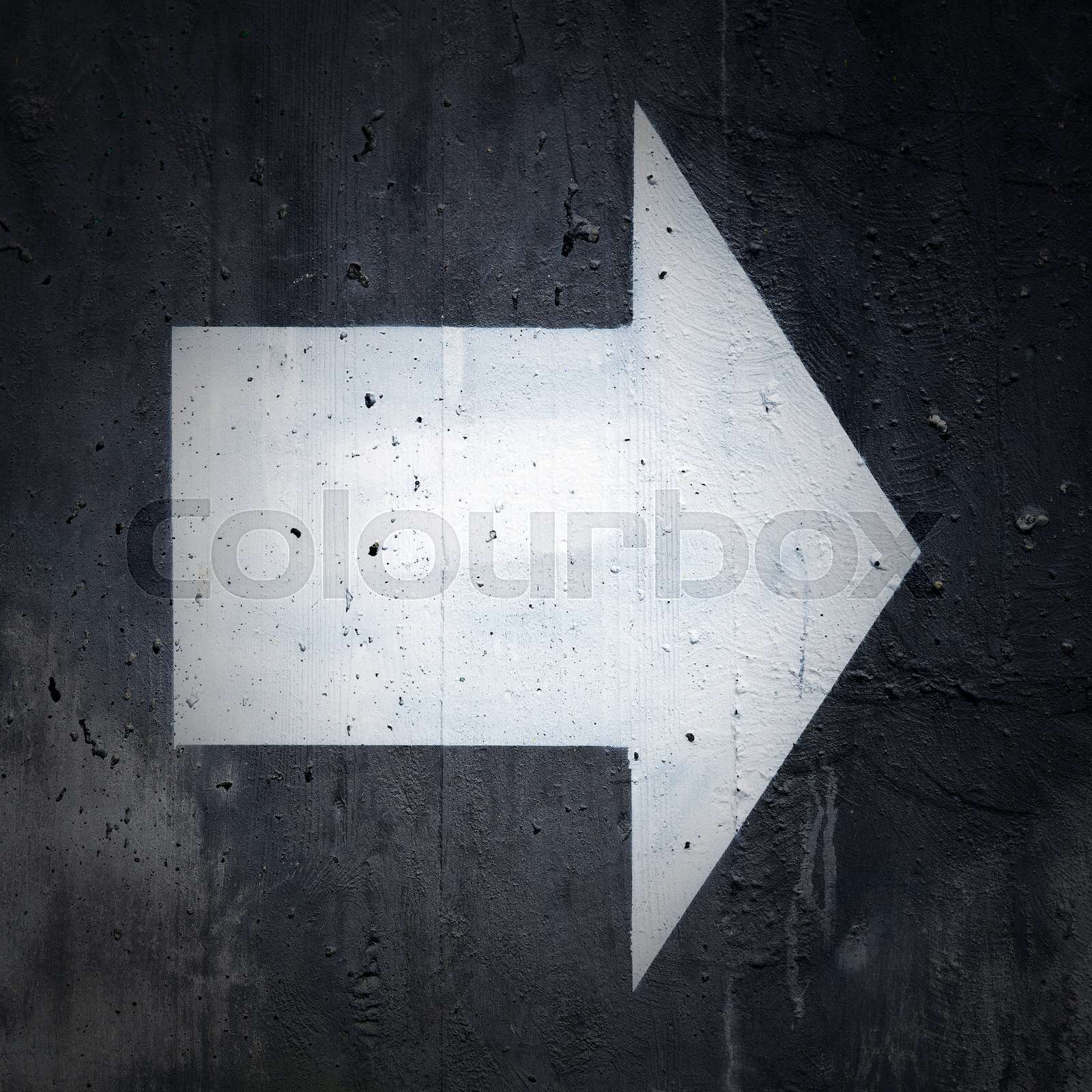 directional arrow pointing to the right on a concrete house wall ...