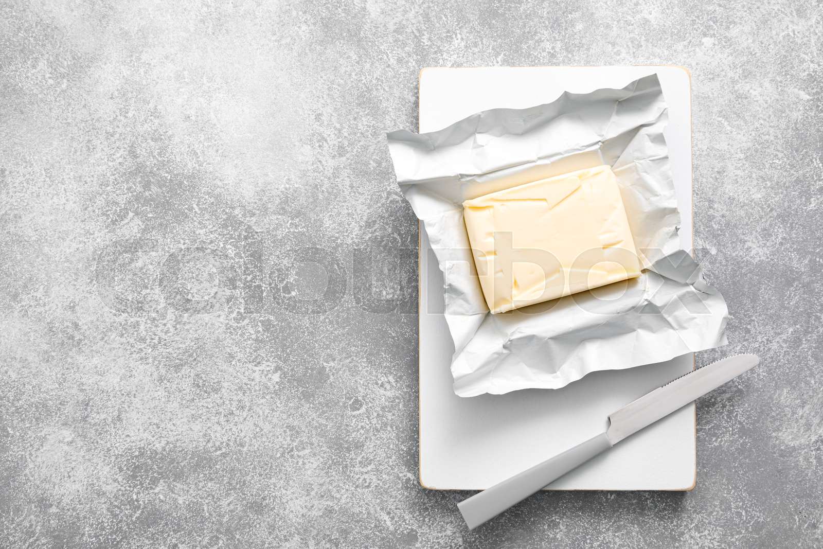 Block of butter with butter knife in a open pack | Stock image | Colourbox