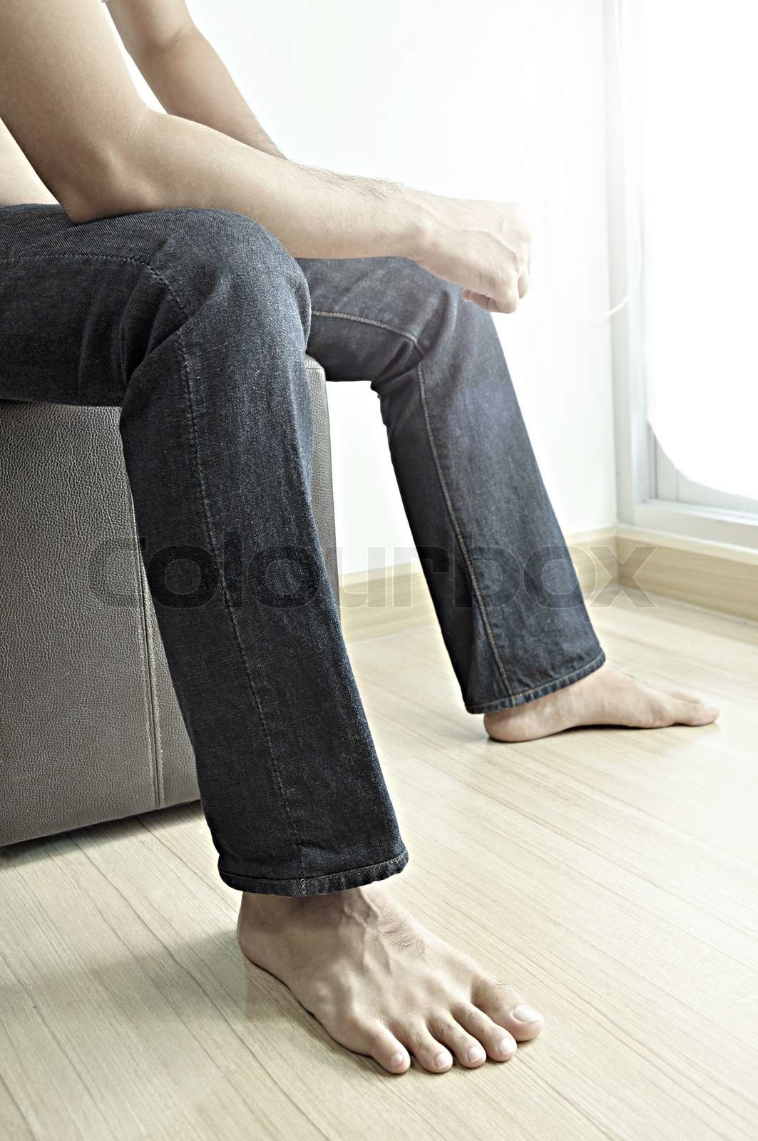 Man wearing jeans sitting on stool | Stock image | Colourbox
