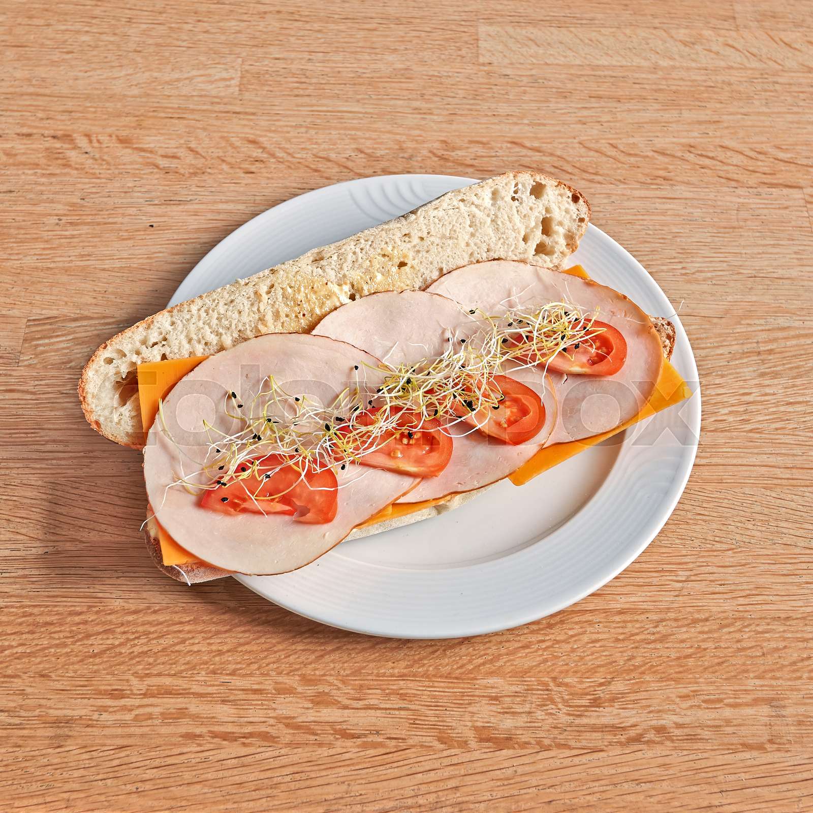 Plate with a Chicken and Cheddar sandwich on wooden table | Stock image ...
