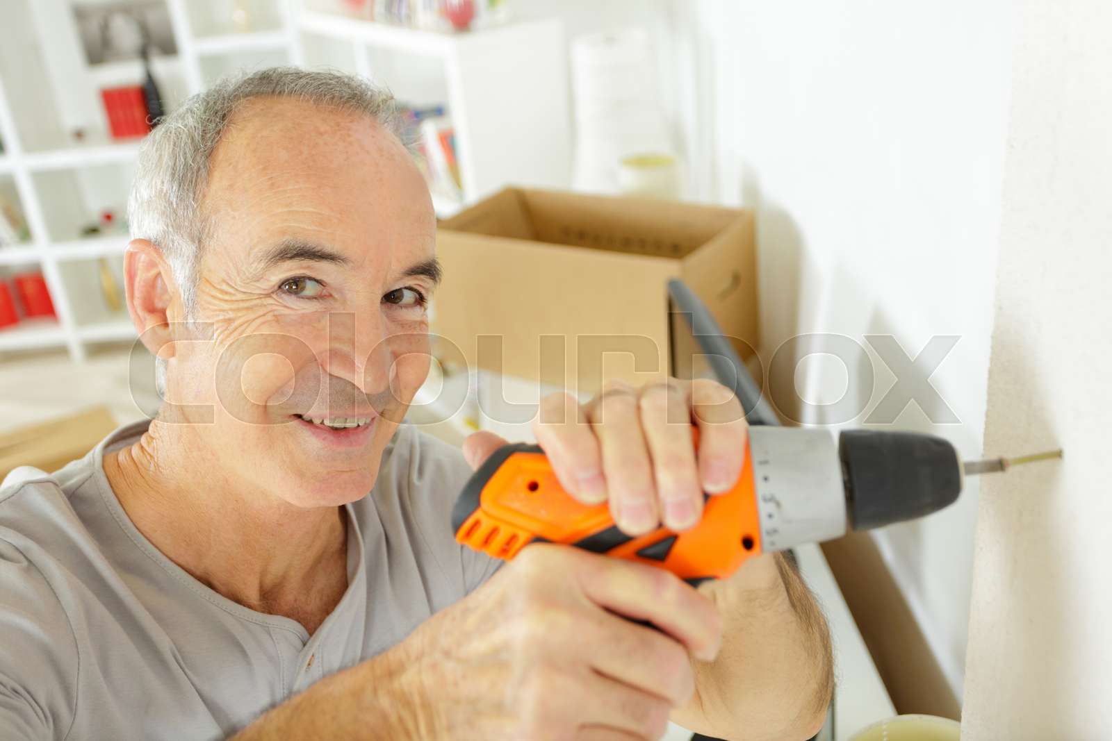 senior man using drill at home | Stock image | Colourbox