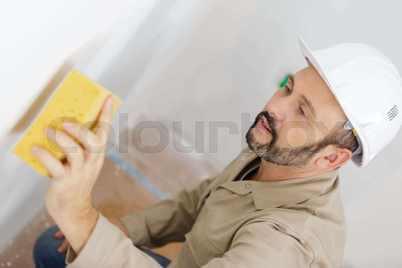 man washing wall after painting it | Stock image | Colourbox