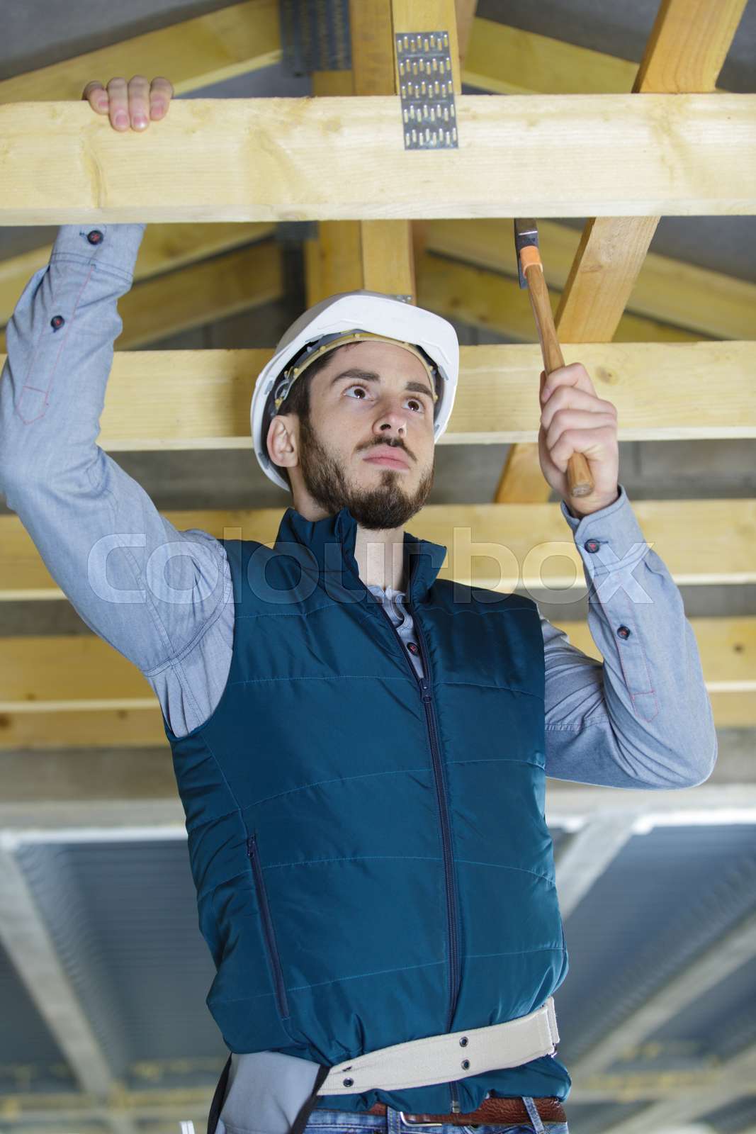 young male contractor working indoors | Stock image | Colourbox