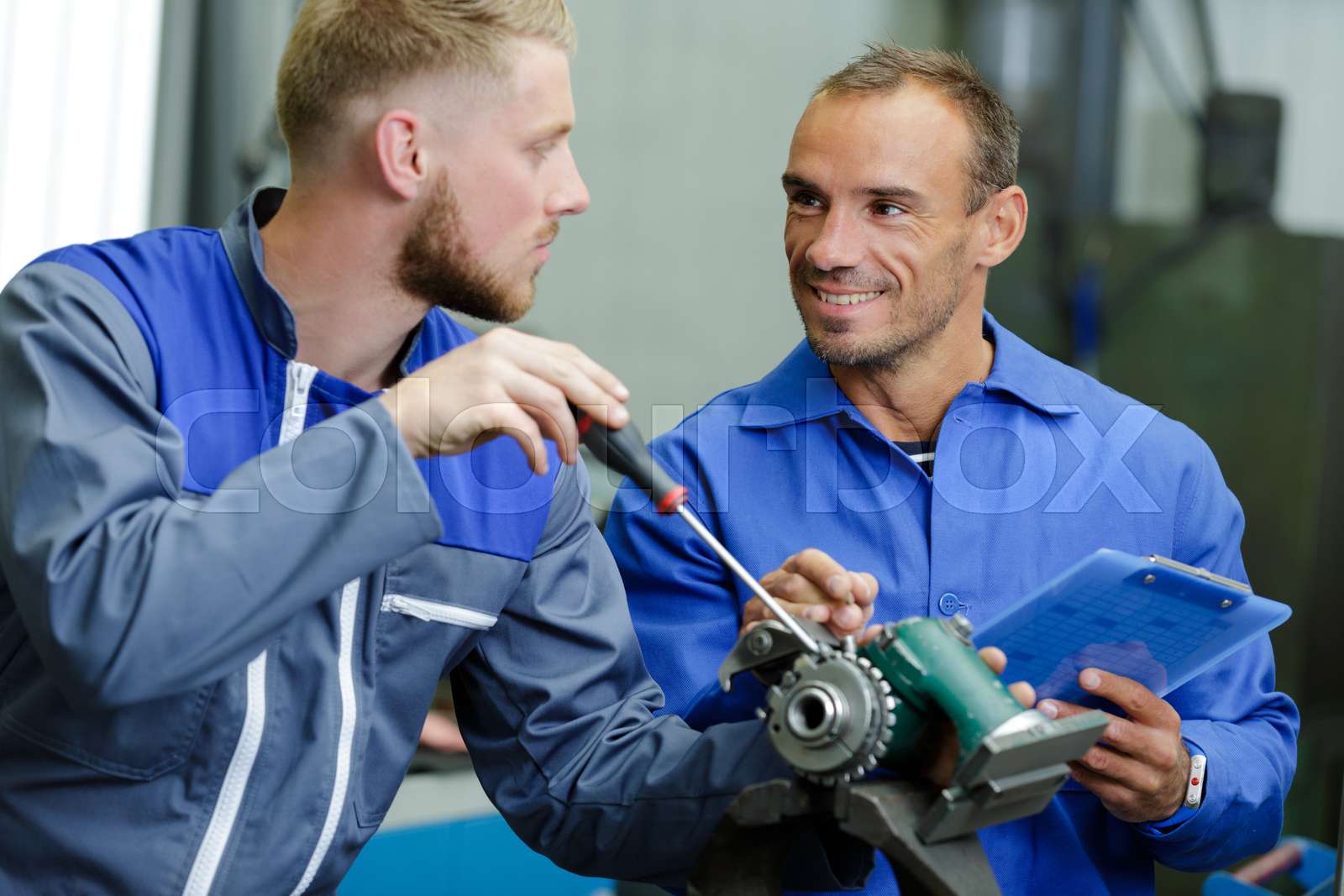 mechanics fixing a pice on a machine | Stock image | Colourbox