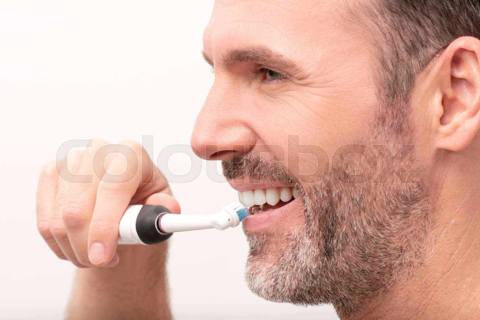 Man using electric toothbrush | Stock image | Colourbox