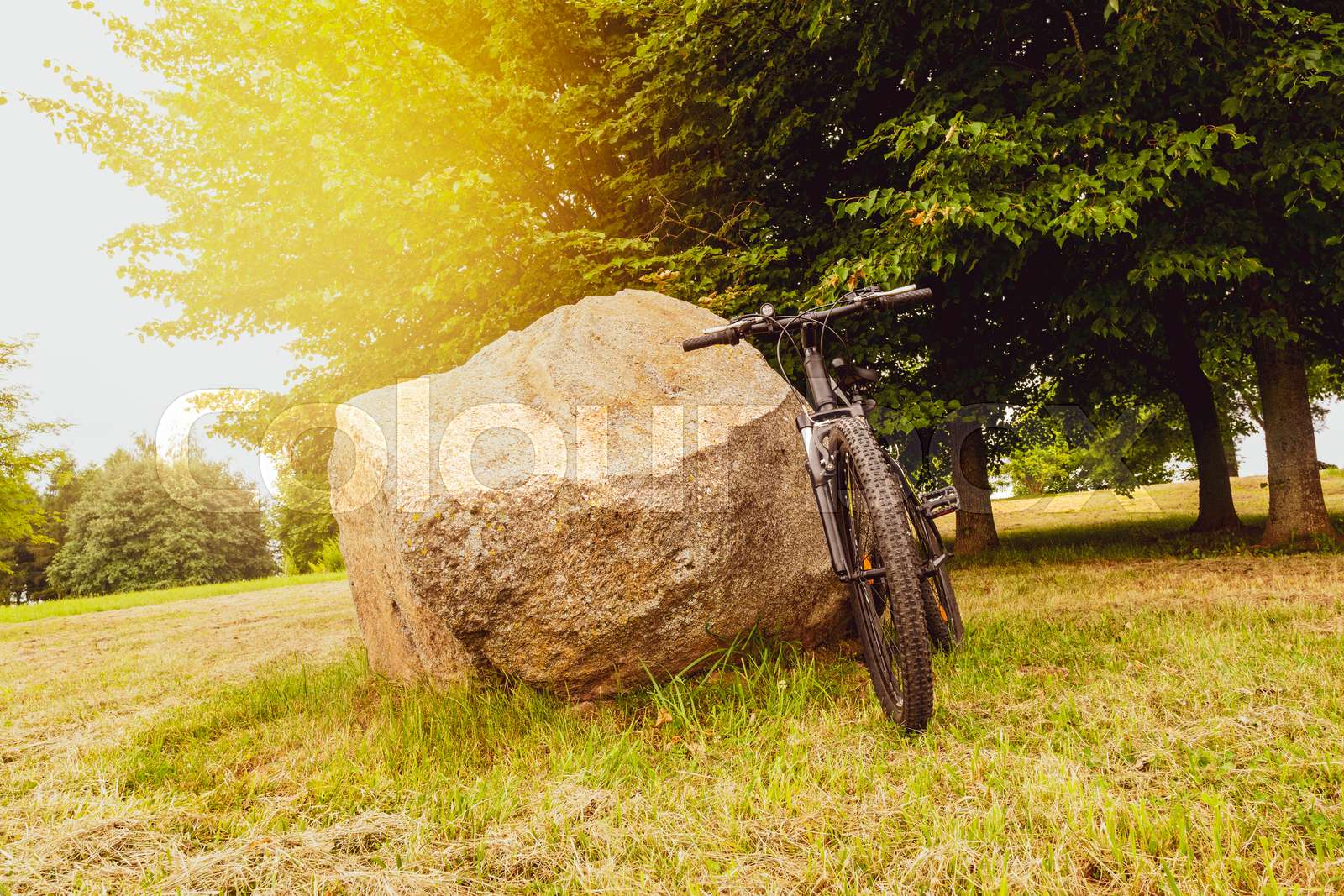 Mountain bike leaned on a big stone | Stock image | Colourbox