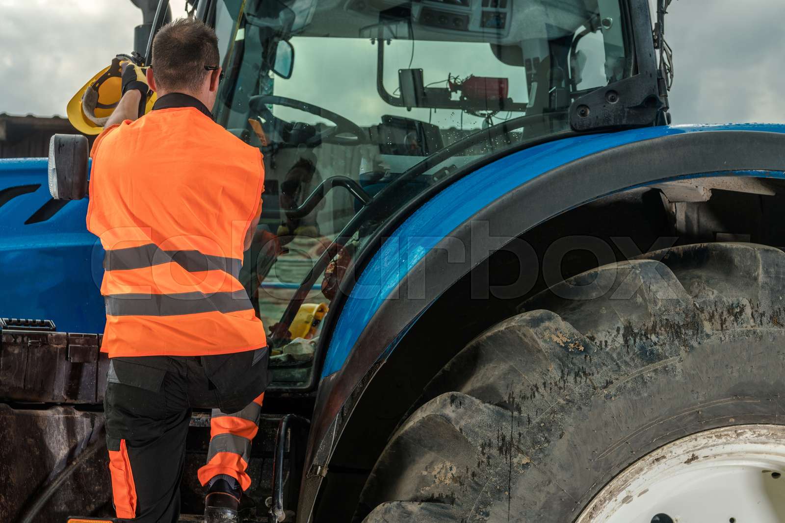 Construction Worker Entering a Tractor | Stock image | Colourbox