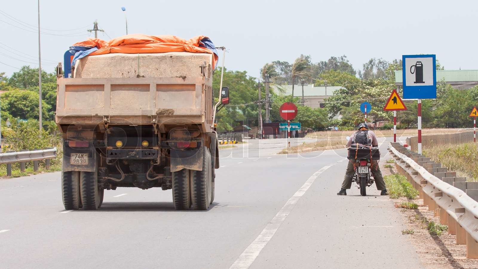 Big truck passing a motorcycle on a highway | Stock image | Colourbox
