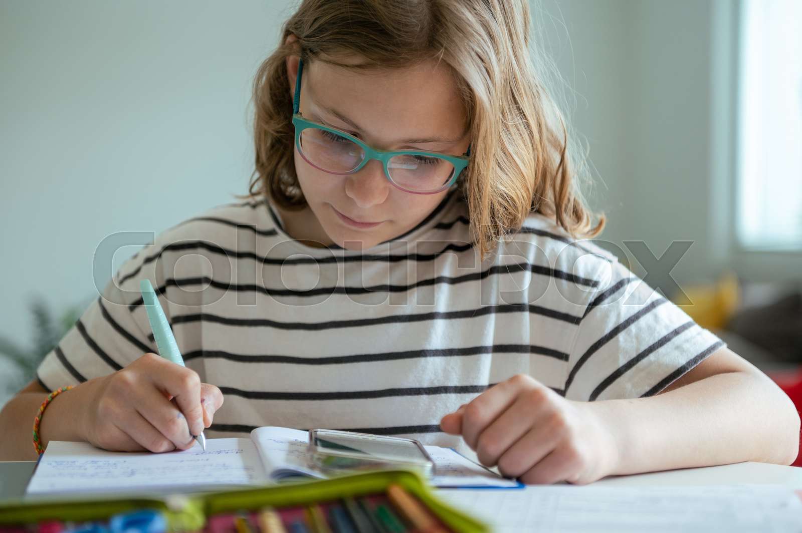 Blonde teen schoolgirl doing her written homework | Stock image | Colourbox