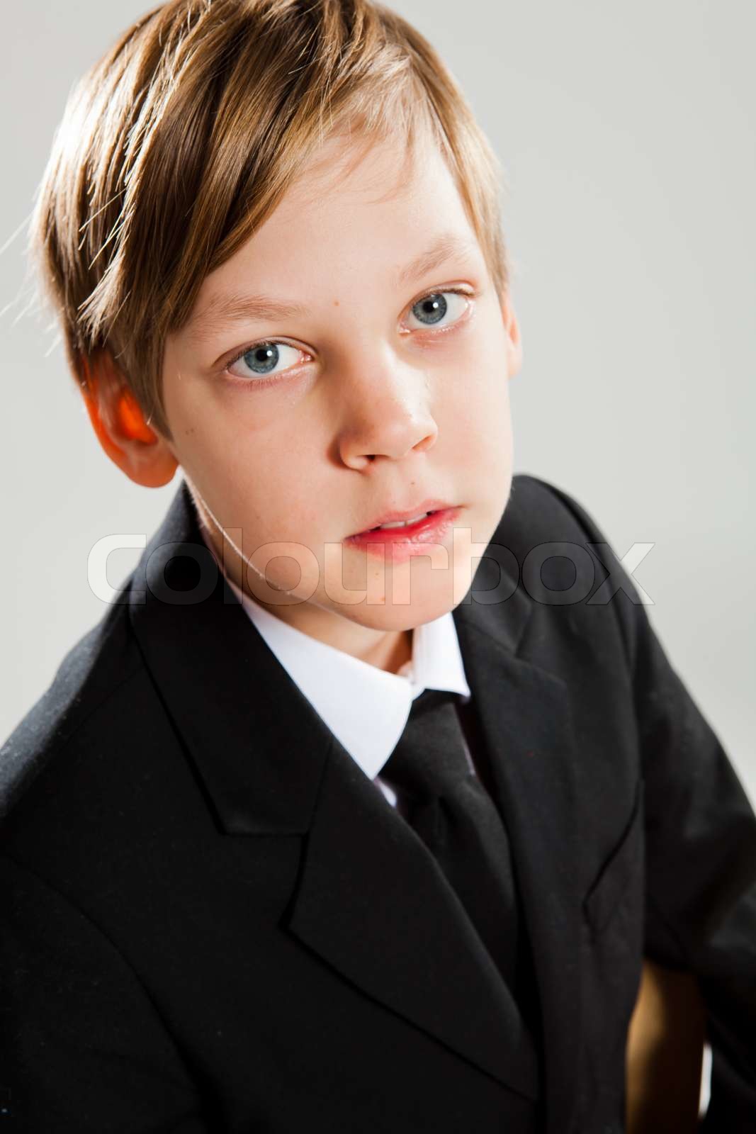Ung dreng iført sort jakkesæt | Stock foto | Colourbox