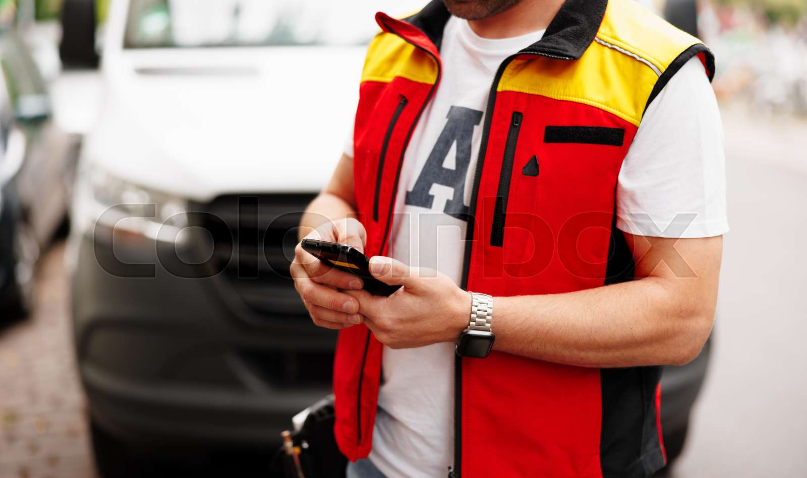 Delivery boy talking on mobile phone with customer while looking for ...