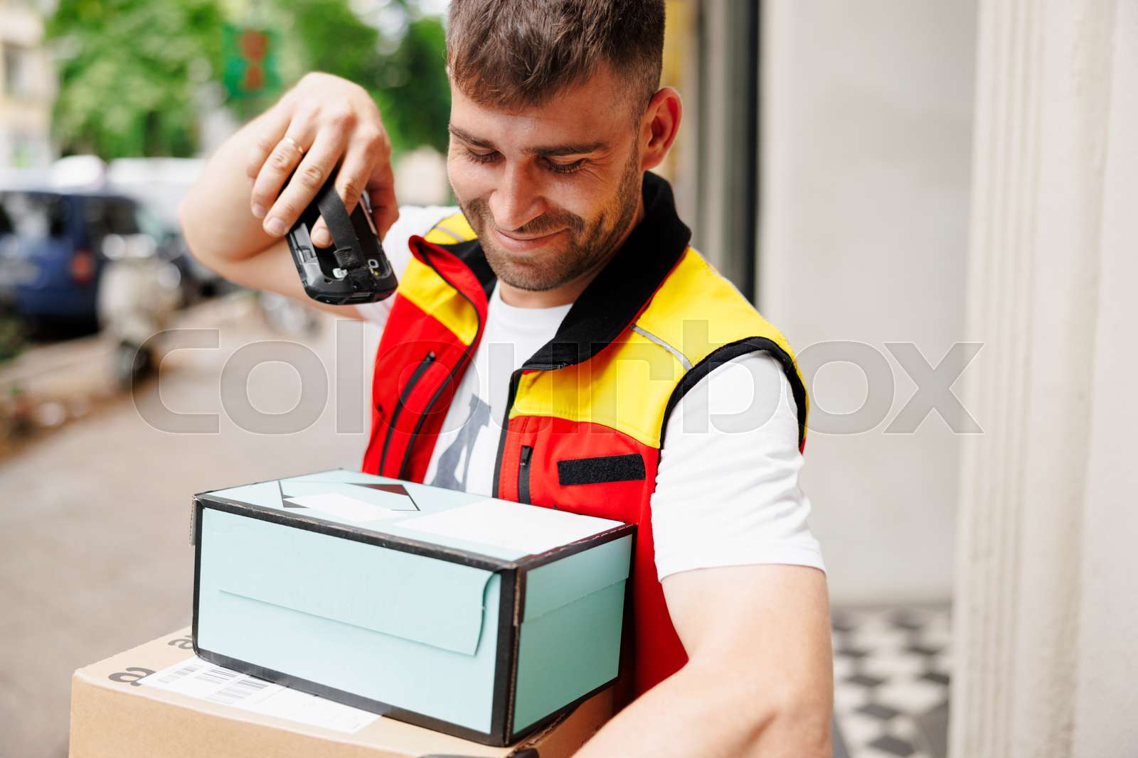 Delivery man scanning boxes a barcode packages with a handheld barcode ...