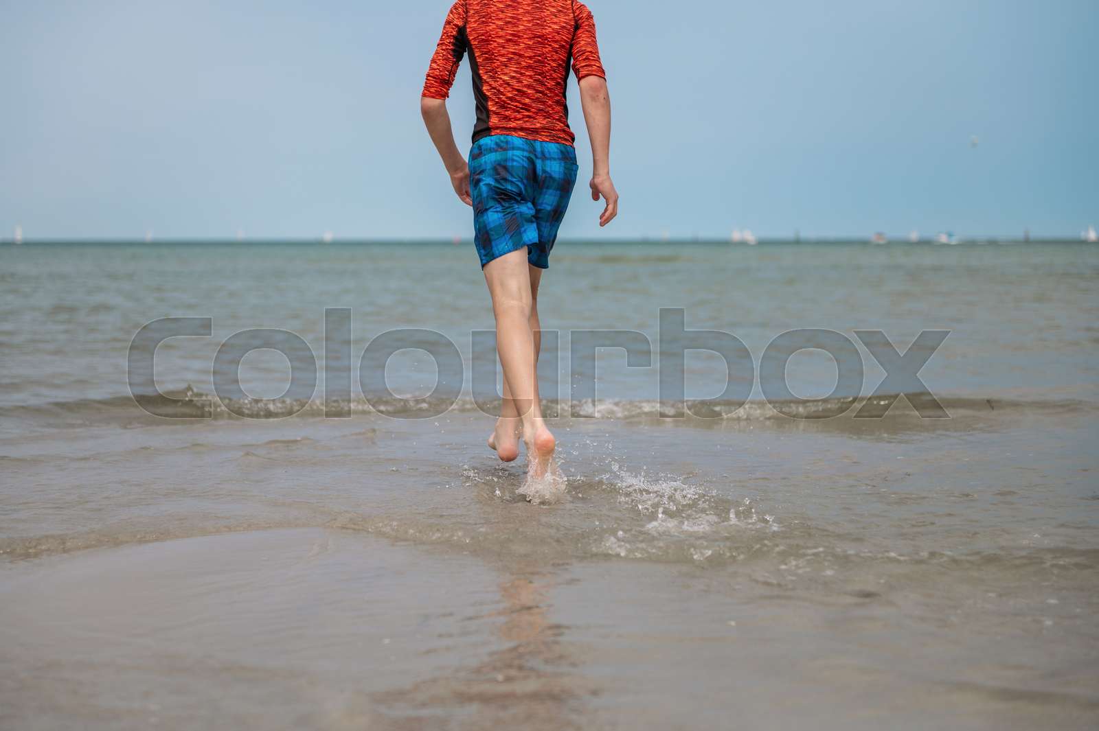 Sporty young boy running in sea at beautiful beach at summer | Stock ...