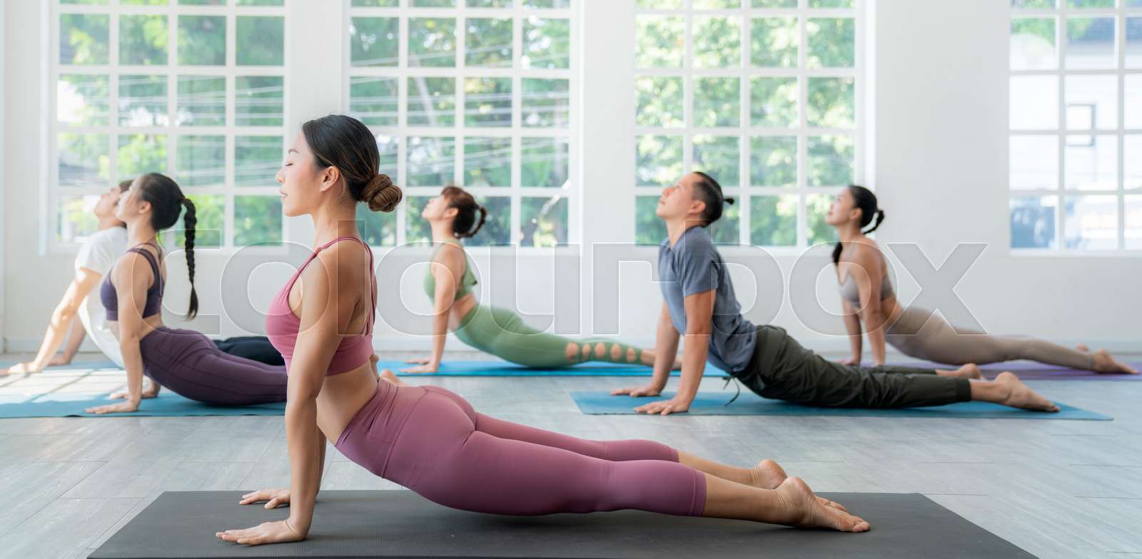 Asian yoga trainer and her student pose yoga basic position in her ...