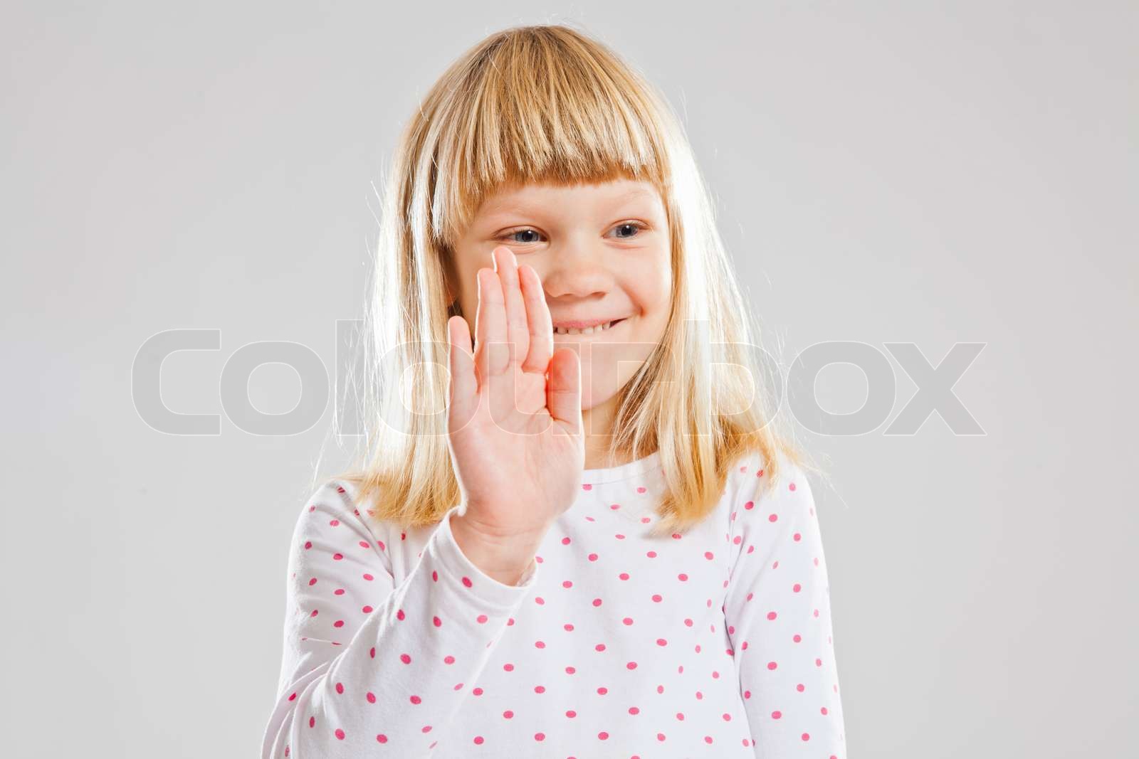 Smiling young girl showing hand signal | Stock image | Colourbox