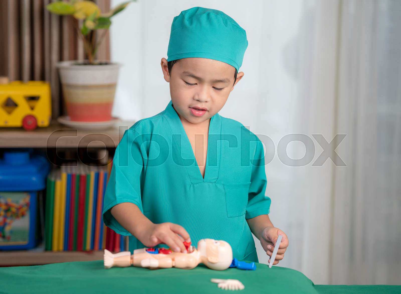 Asian boy play surgery with toy | Stock image | Colourbox