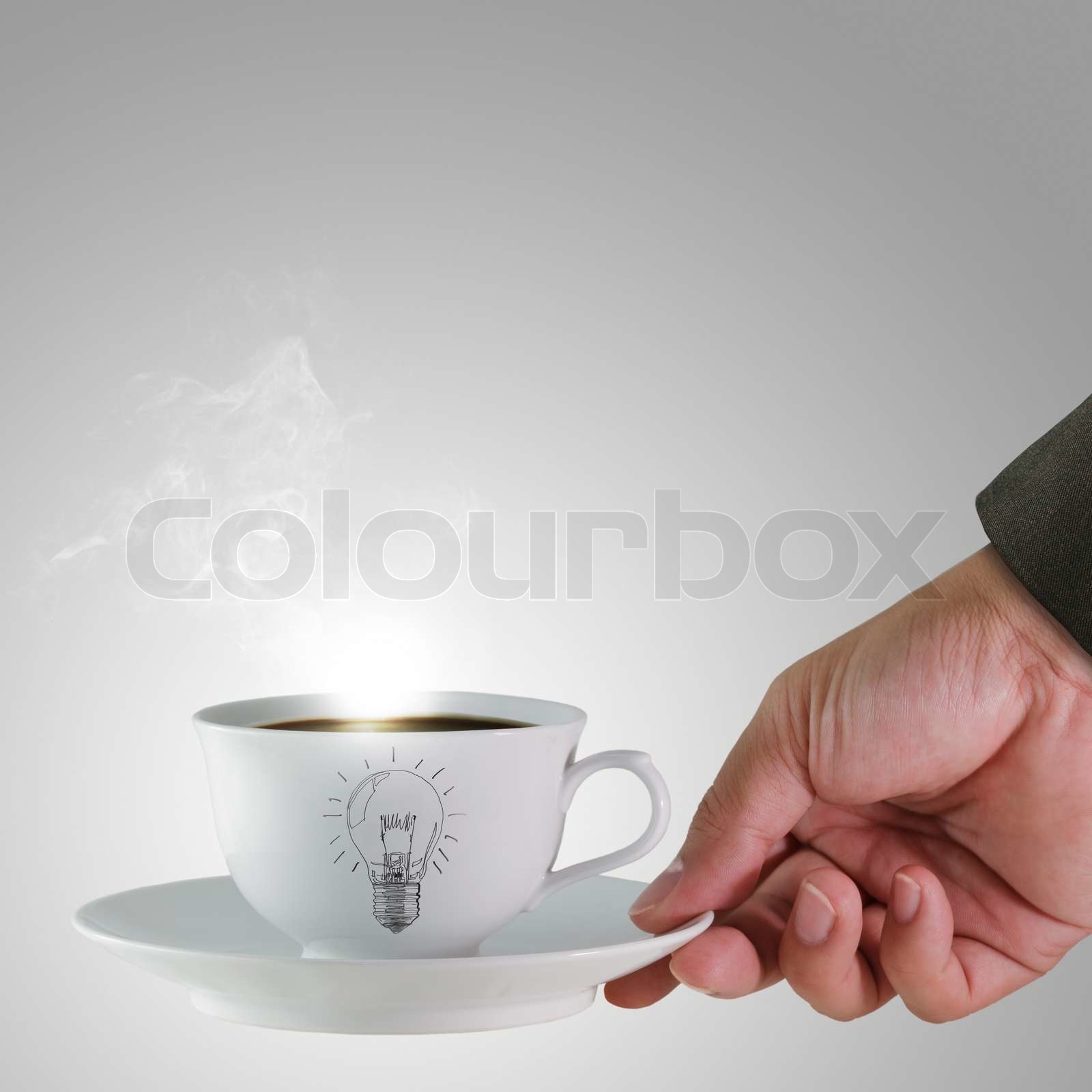 hånd og en kop kaffe med pære tegning som begreb | Stock foto | Colourbox