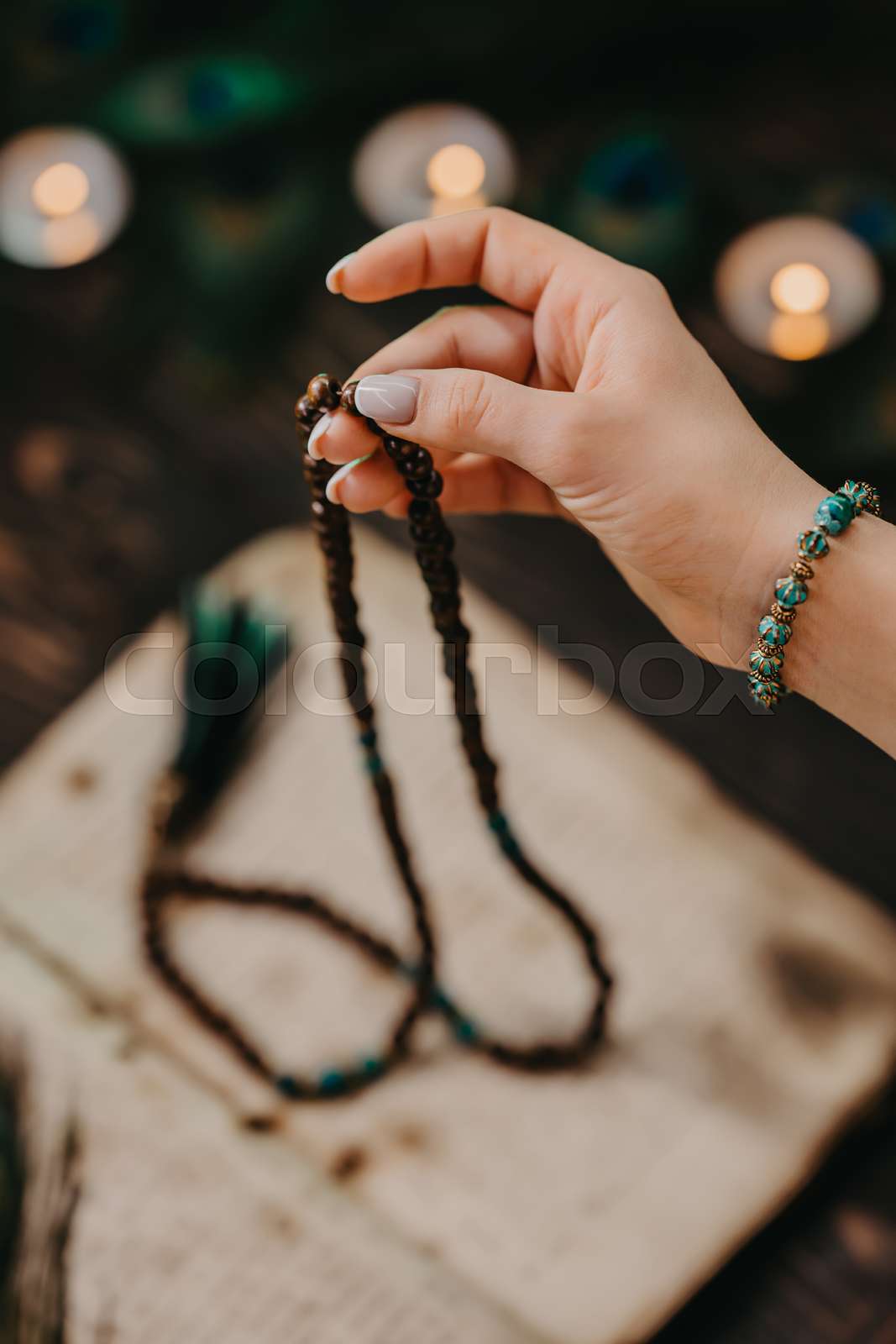 Woman reading mantras or prayers from ancient Holy Book, counts malas ...