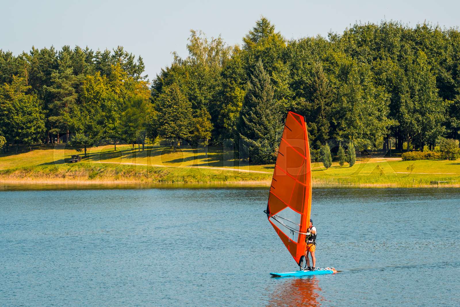 Surfer sailing with sail board in the water | Stock image | Colourbox