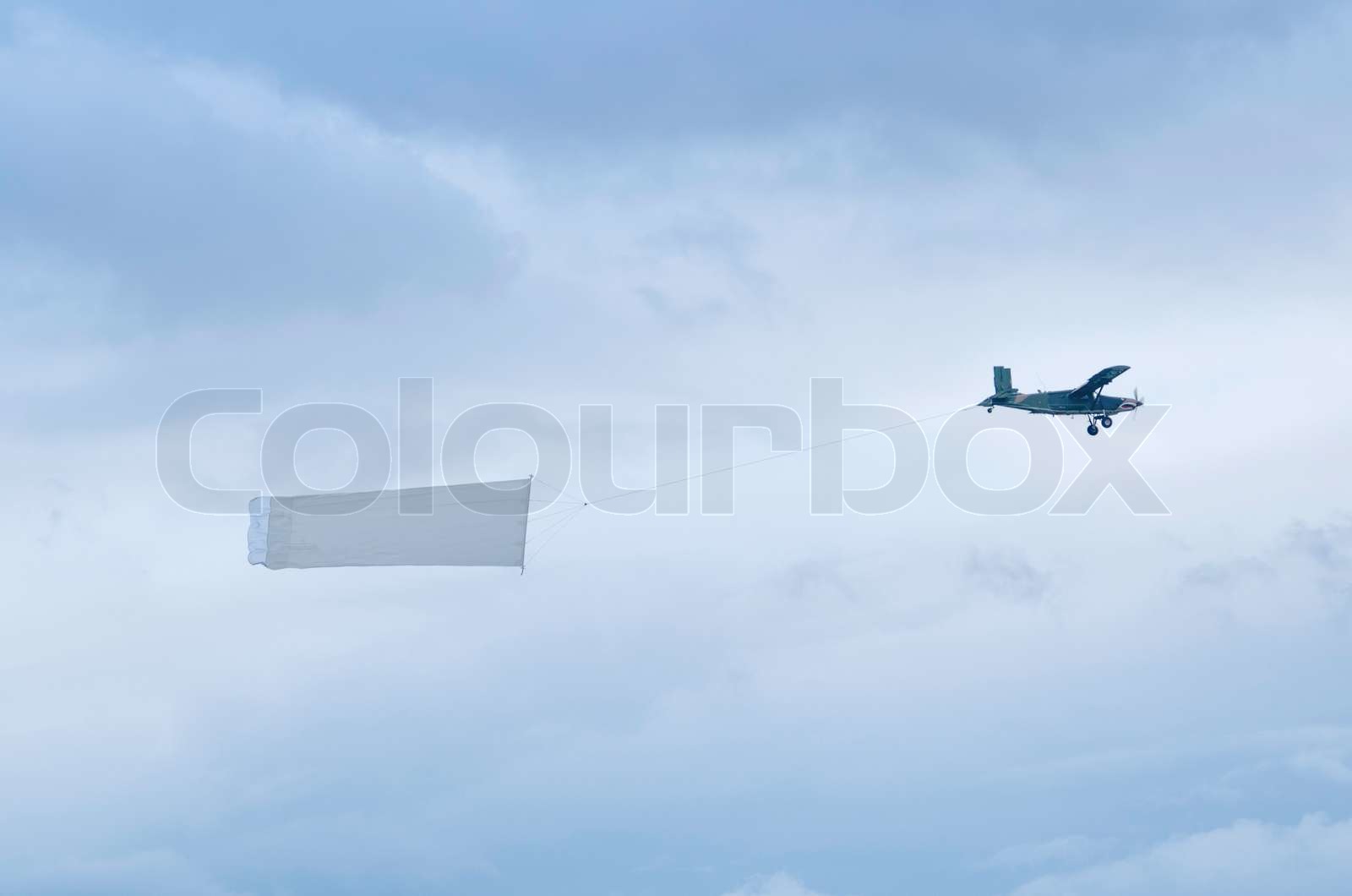 Et fly flyver gennem luften trække et tomt, hvidt banner til at tilføje ...