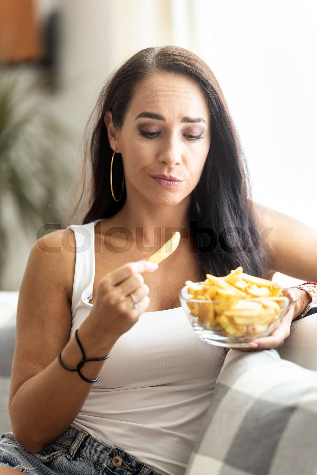 Woman hesitates about eating french fries due to unhealthy food effect ...