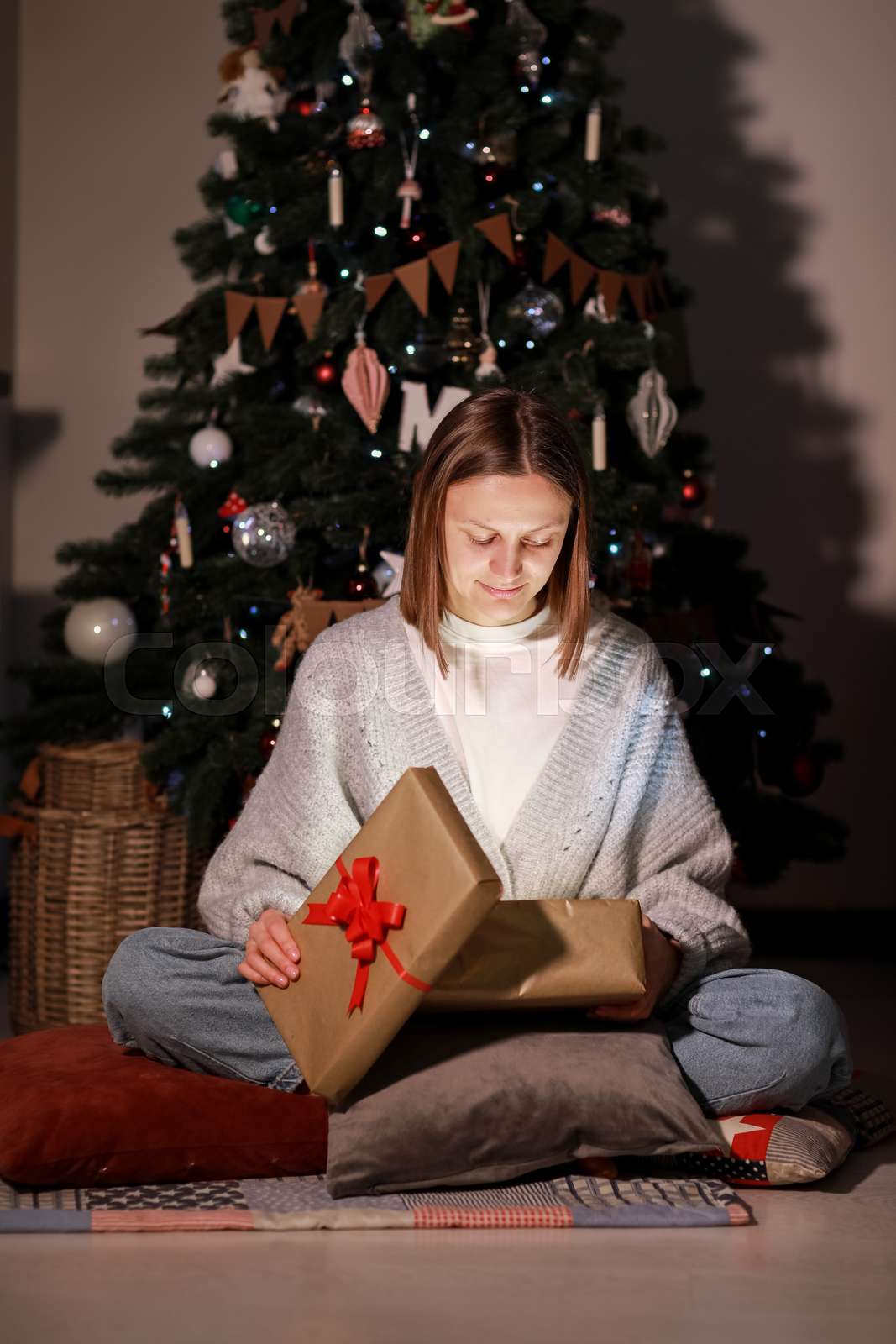 The Magic Of Christmas. Amazed young beautiful woman opening xmas gift ...
