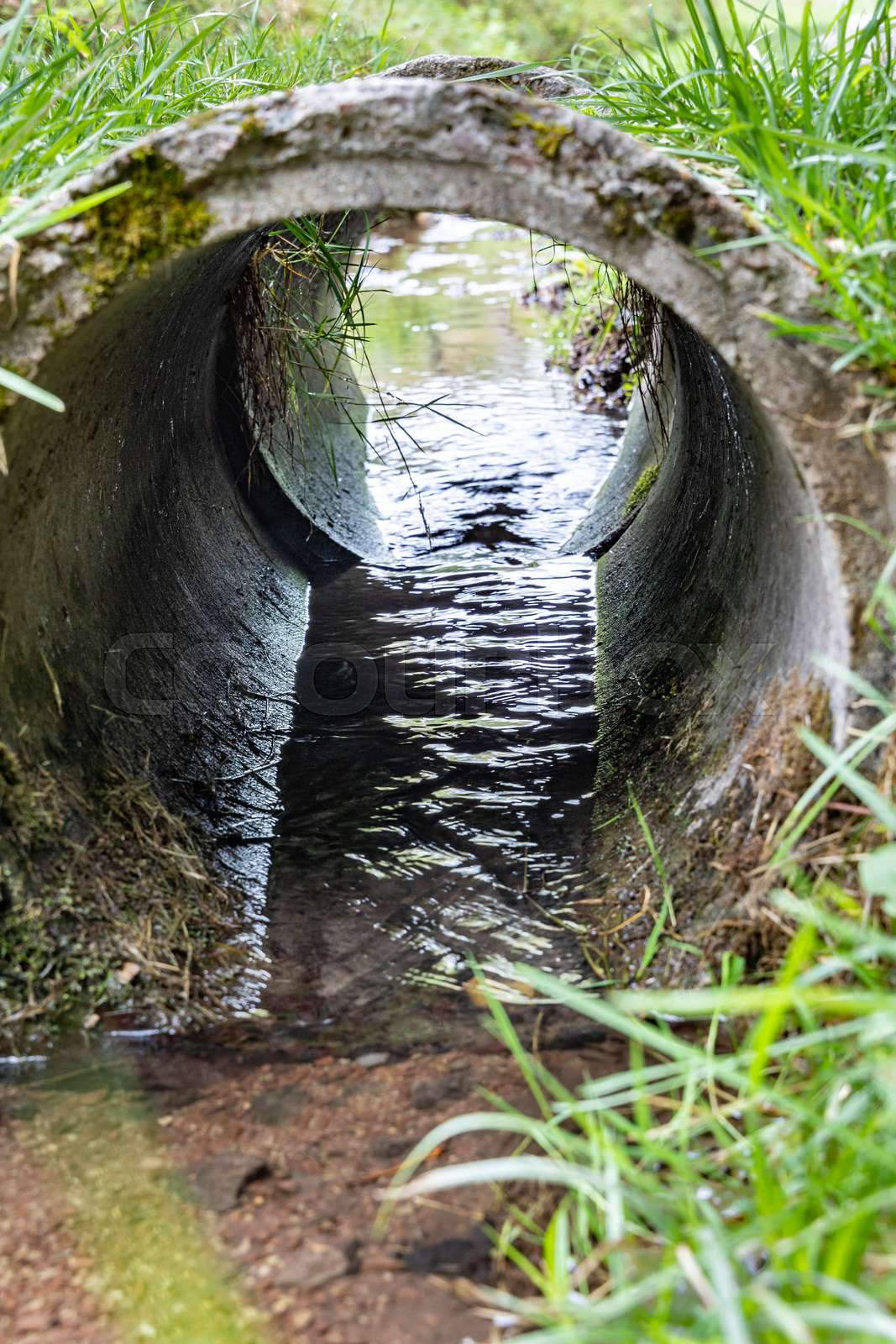 The stream runs through the pipe | Stock image | Colourbox