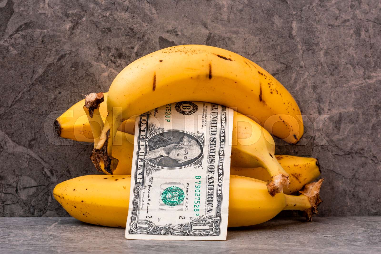 Pile of ripe bananas with one dollar banknote | Stock image | Colourbox