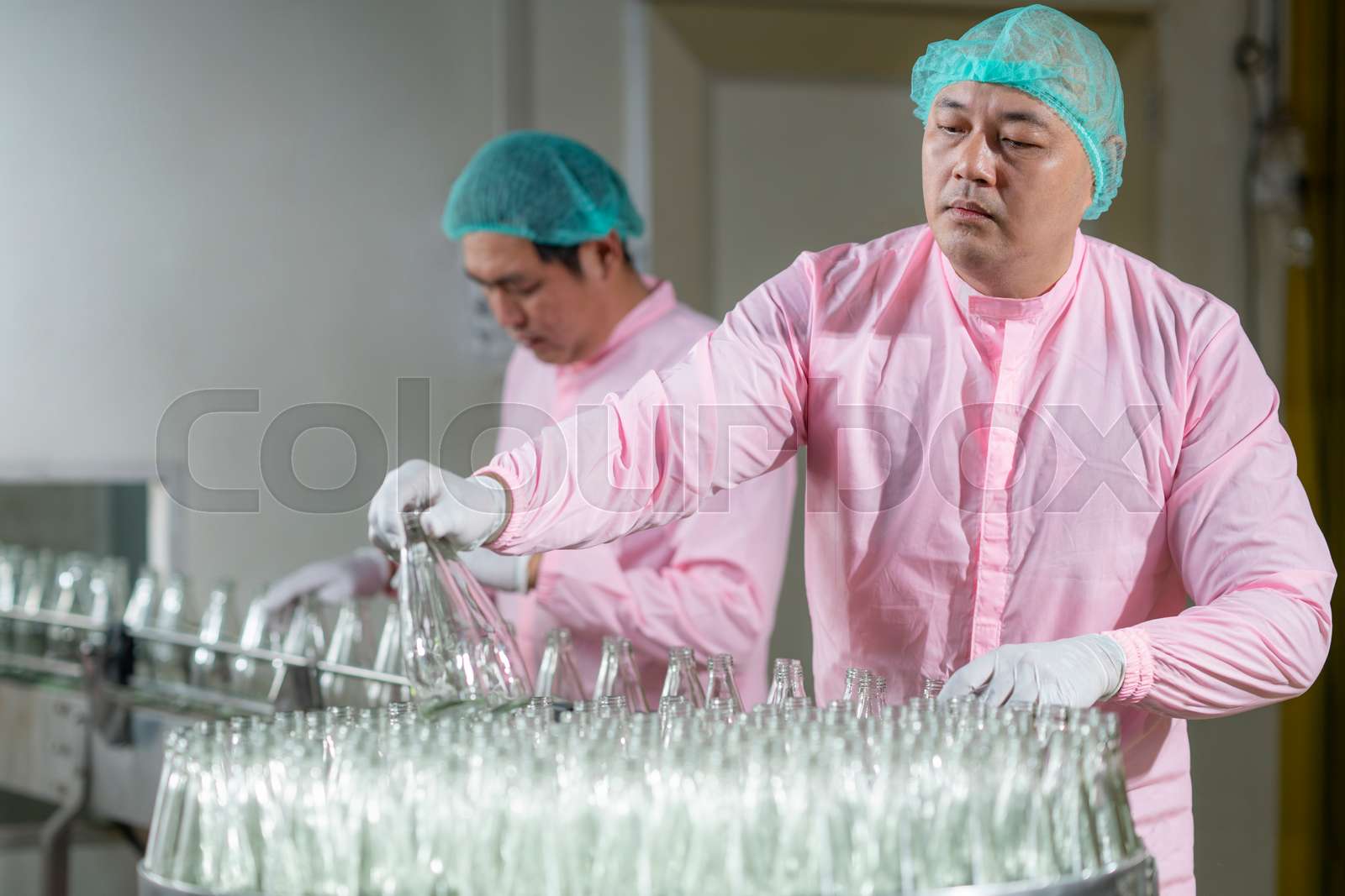 Operator worker working at Raw glass bottles on an aytomatic conveyer ...