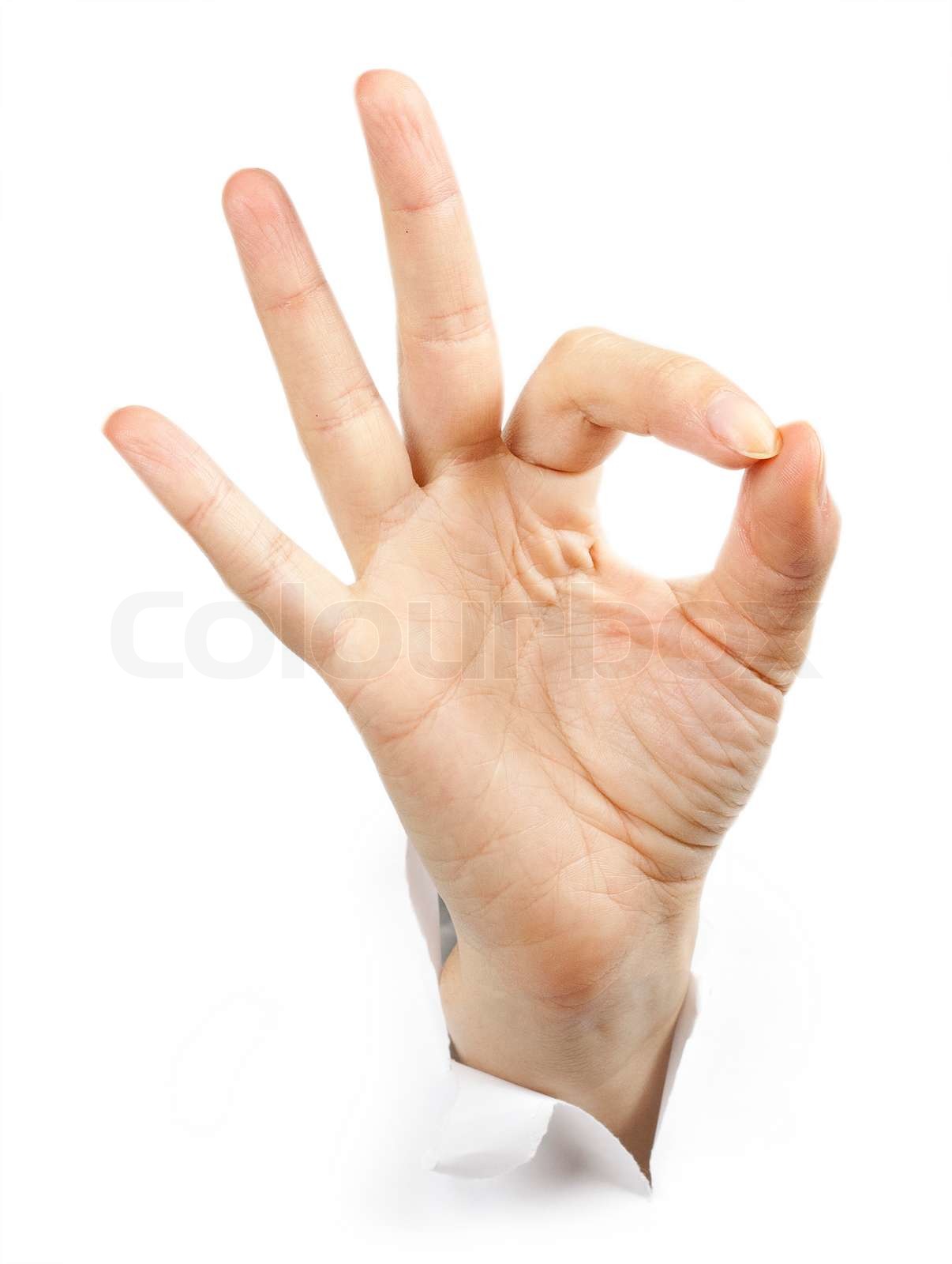 Fingers showing ok sign bursting through paper | Stock image | Colourbox
