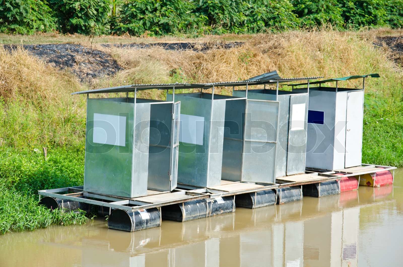 Public toilets float on the water during a flood. | Stock image | Colourbox