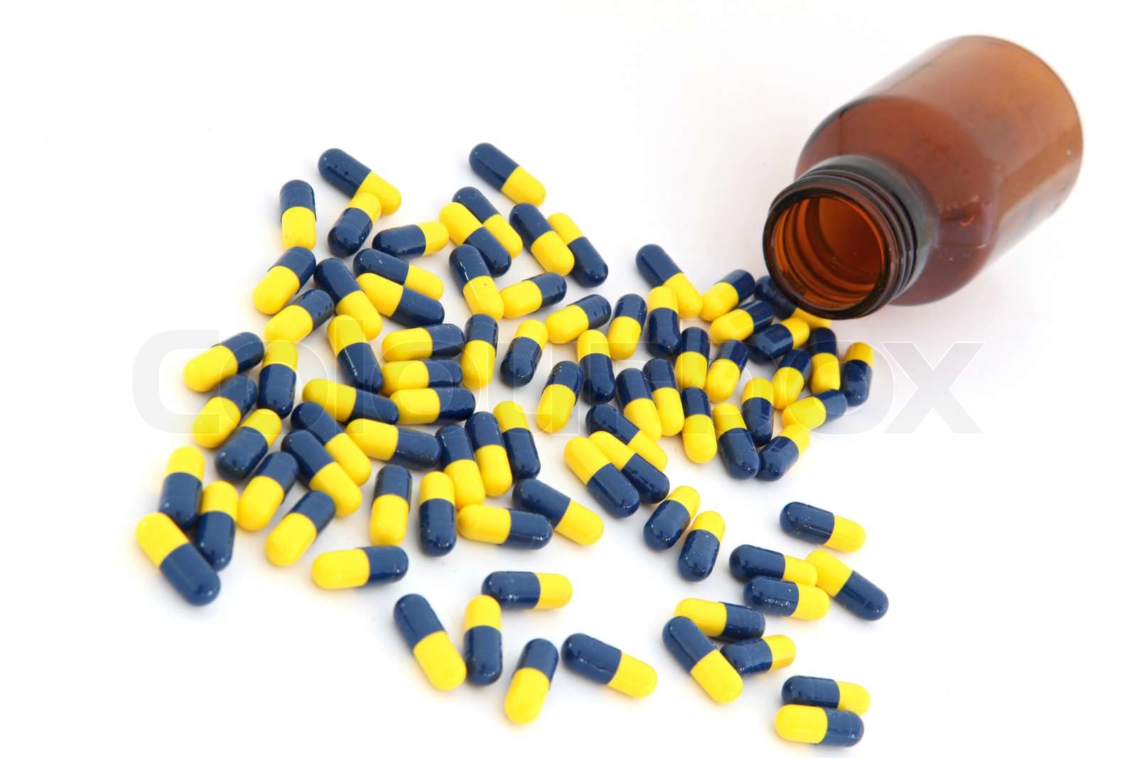 Open pill bottle with capsule spilling out of it | Stock image | Colourbox
