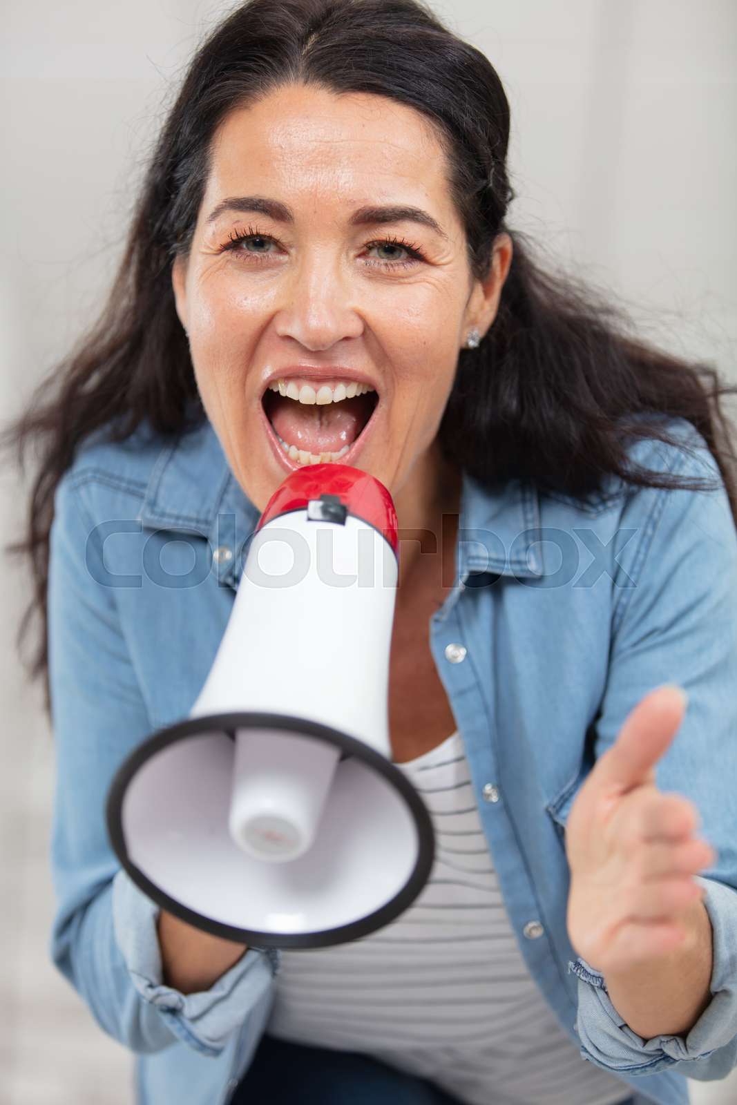middle aged woman yelling through megaphone | Stock image | Colourbox
