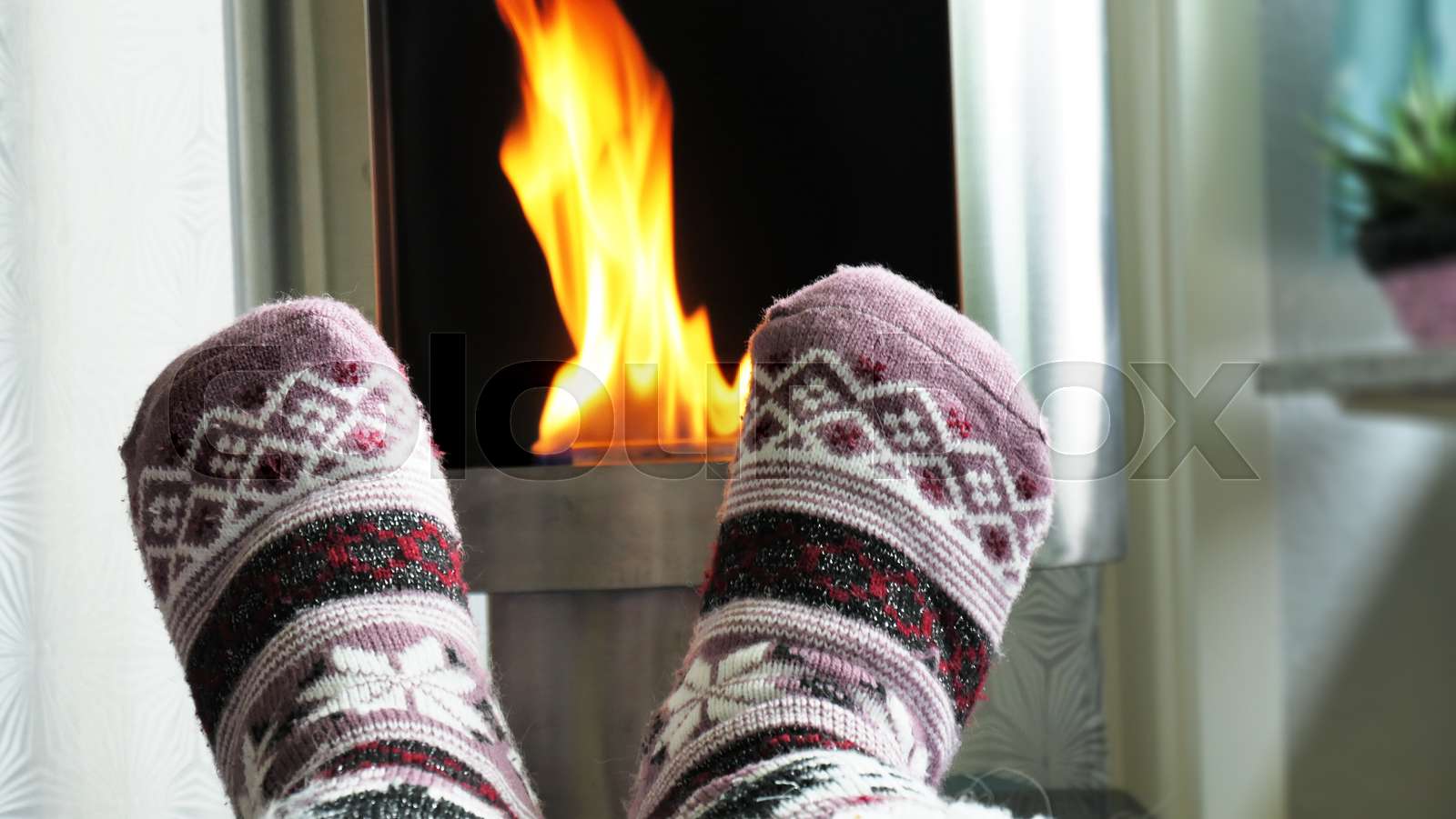 Kolde fødder med varme sokker foran bioethanol pejs ildsted i en kold ...